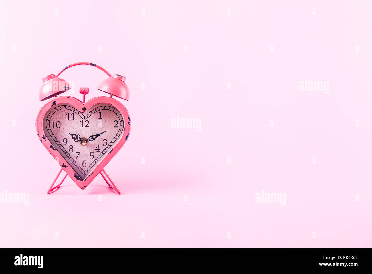 Heart shaped clock on pink background. Valentines day and love infitity ...