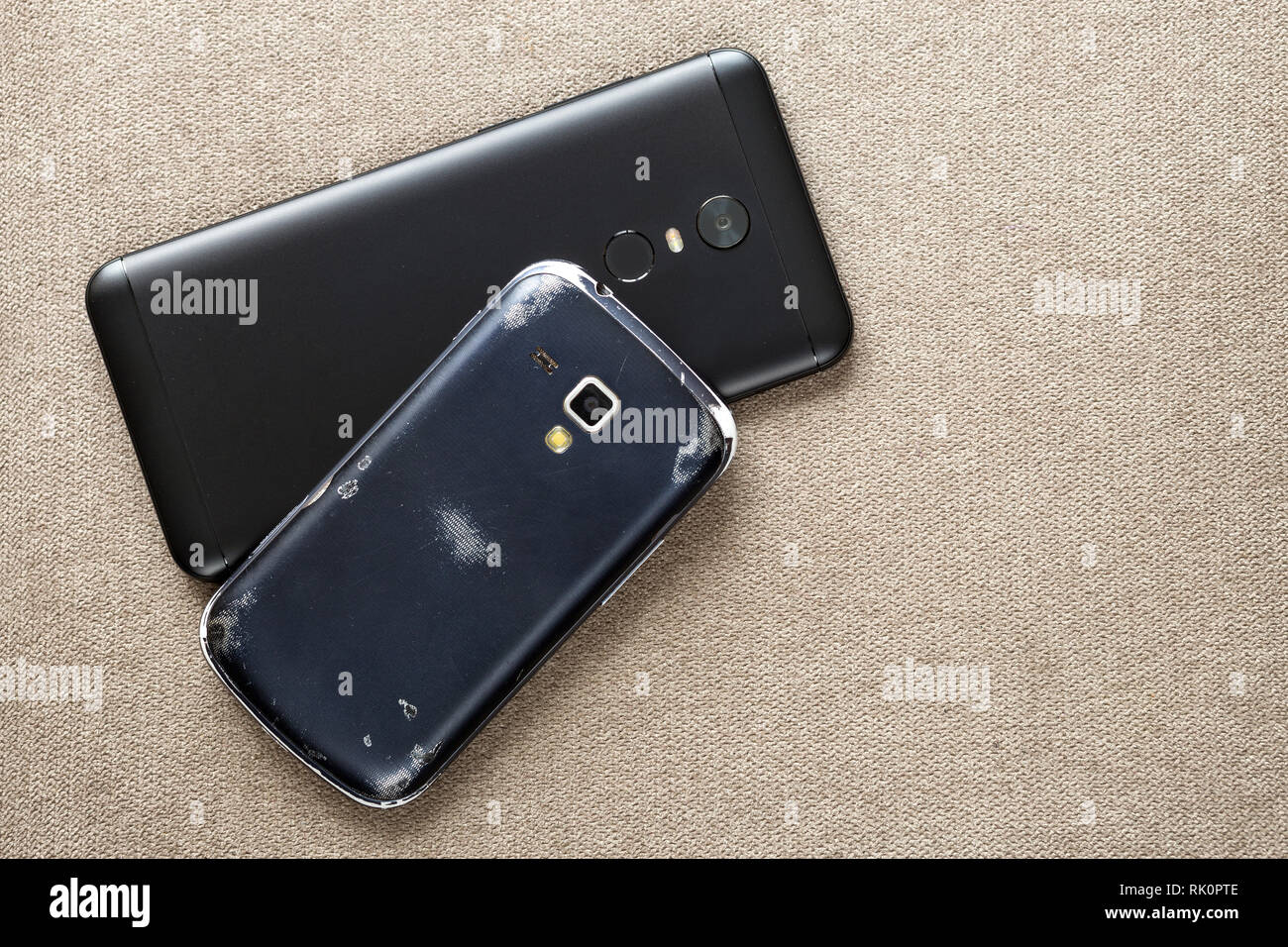 Comparison of two black mobile phones, old cellphone and new modern on ...