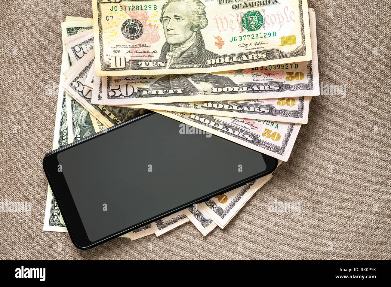 New black modern cellphone on money dollars banknotes background ...