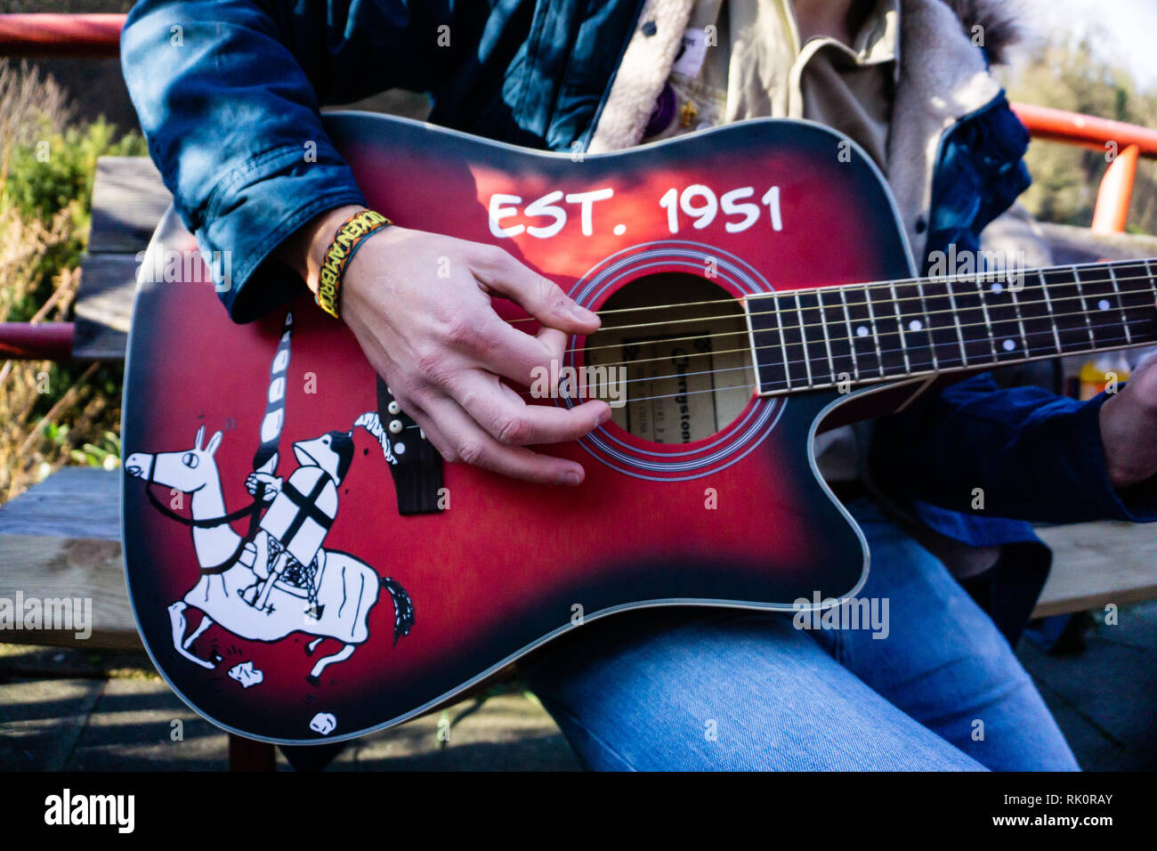 Guitar electric Guitarist playing red music instrument in hands closeup ...