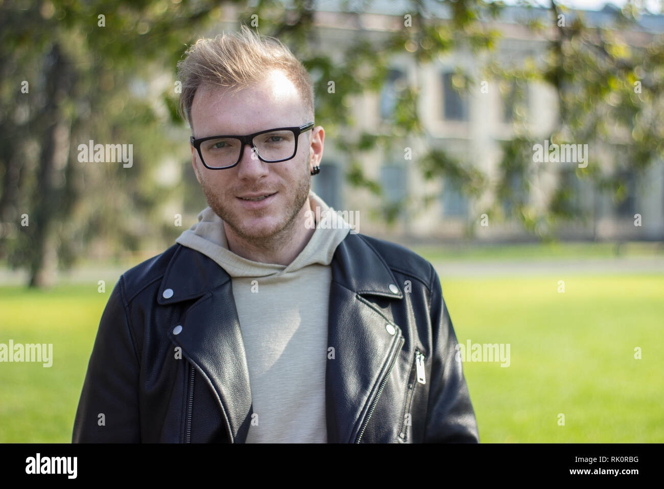 Portrait of a smart smiling guy in casual clothes, looking straight ...
