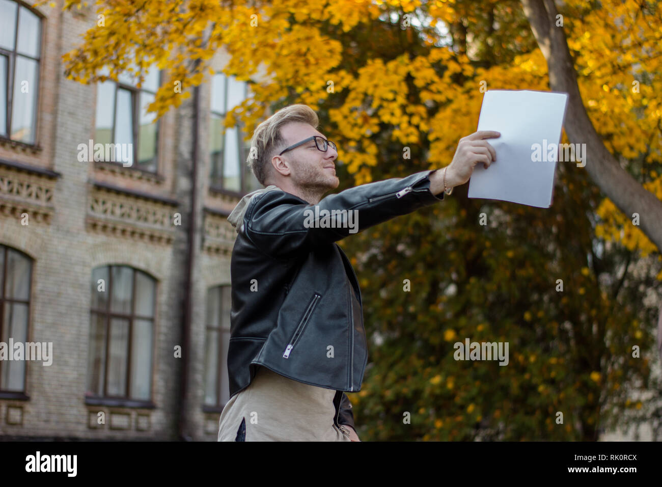 Happy smart student in casual clothes holds papers and looks away Stock ...
