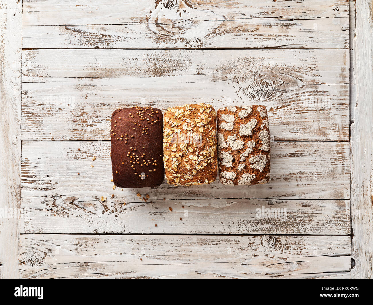 Three loaves of bread on white wooden background. Bakery concept with ...