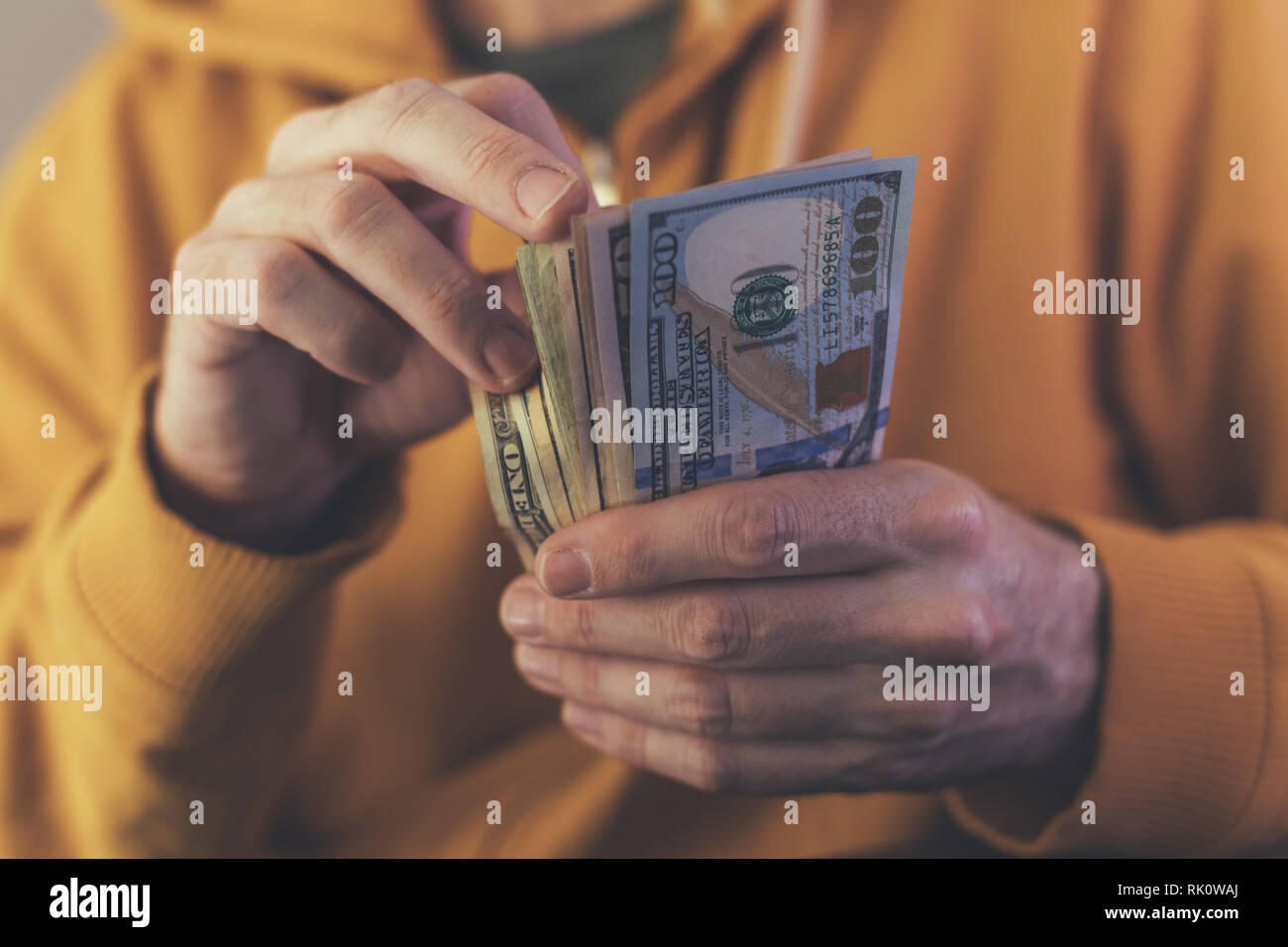 Casual man is counting american dollar banknotes, close up of hands ...