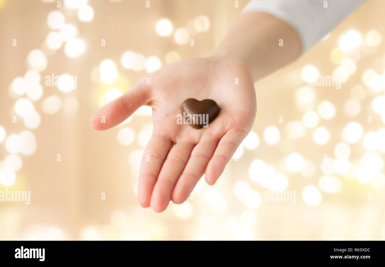 close up of hand with heart shaped chocolate candy Stock Photo - Alamy