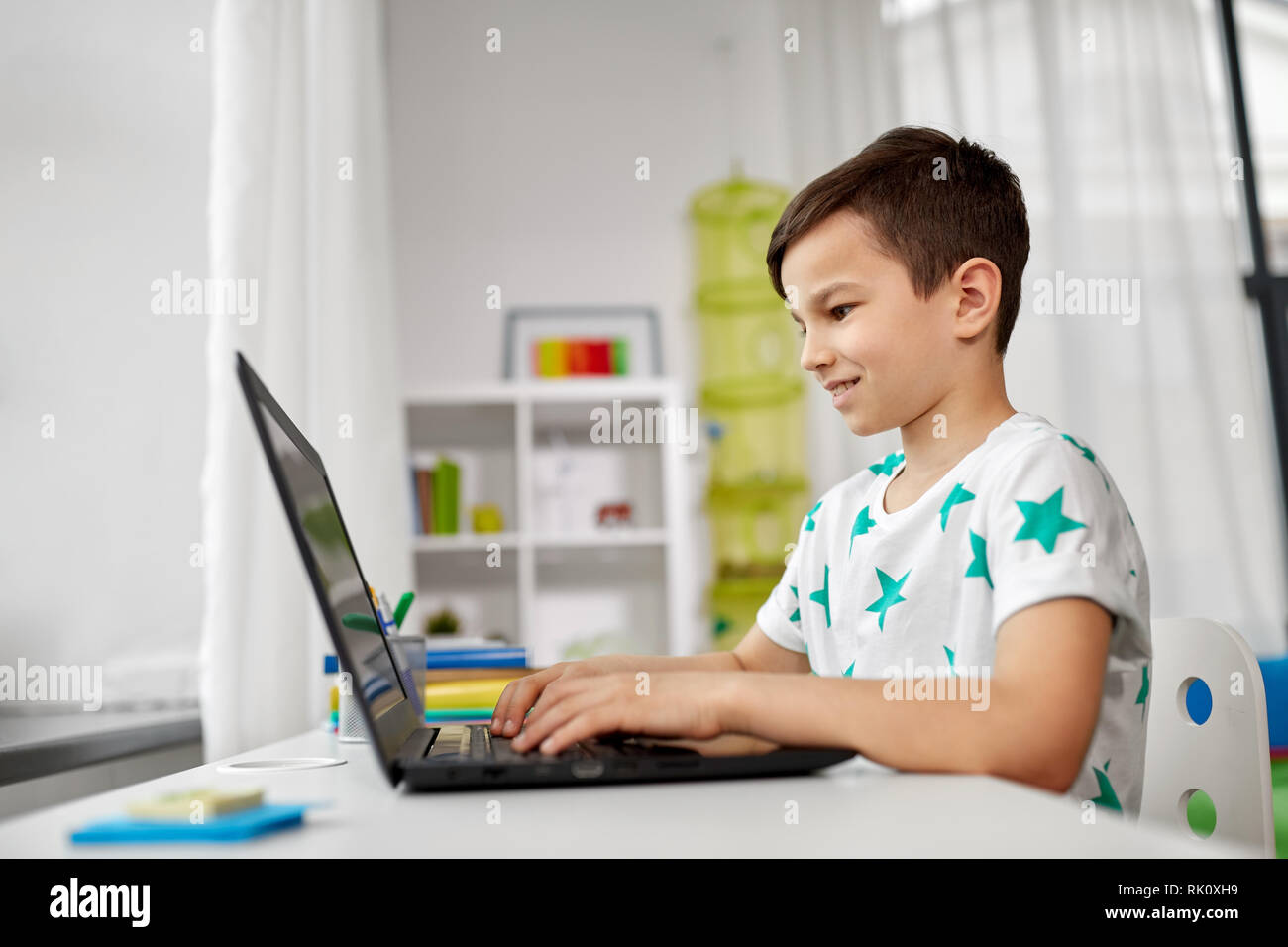 student boy typing on laptop computer at home Stock Photo - Alamy
