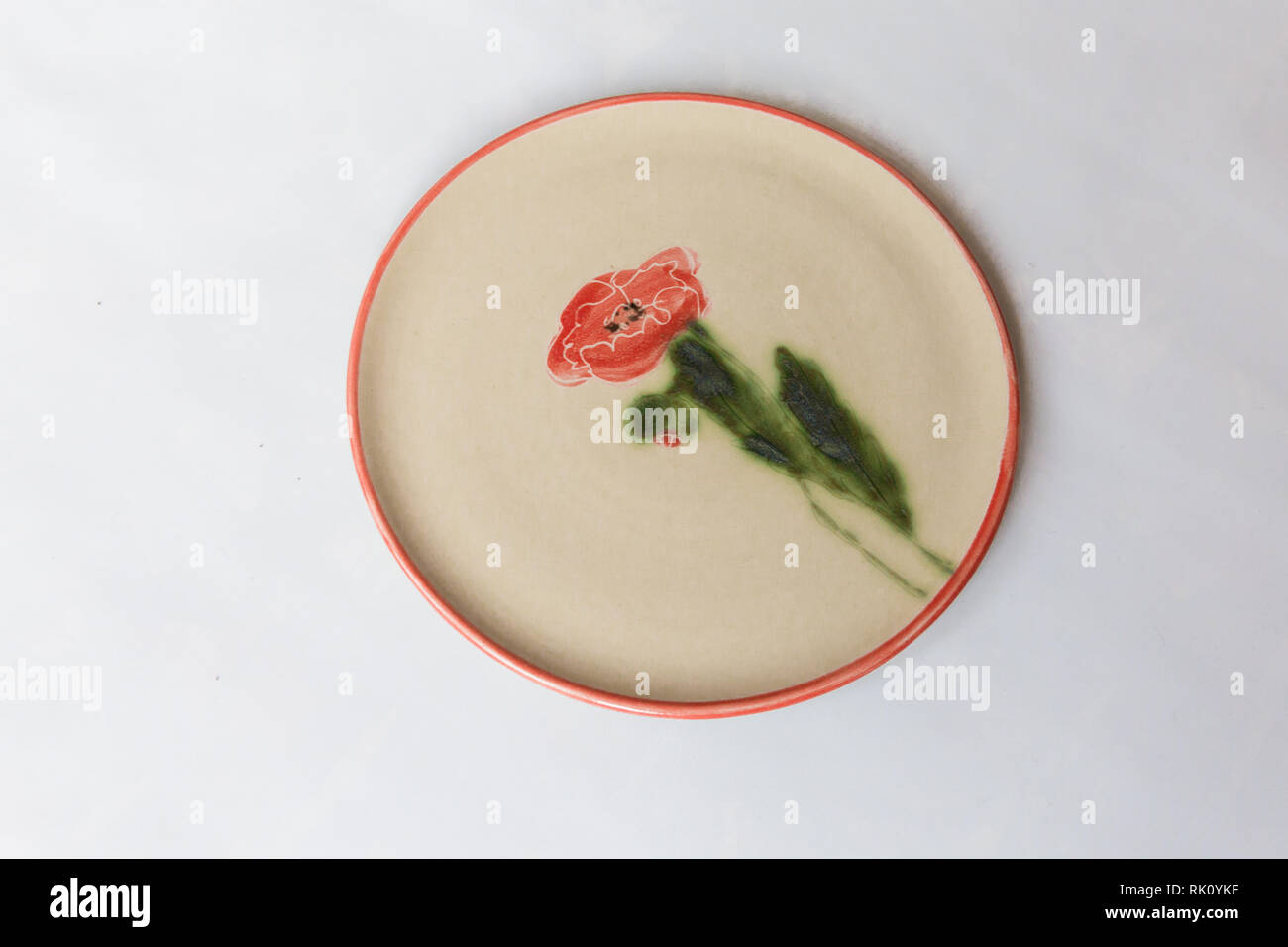 a white round plate with floral and line pattern on white background ...