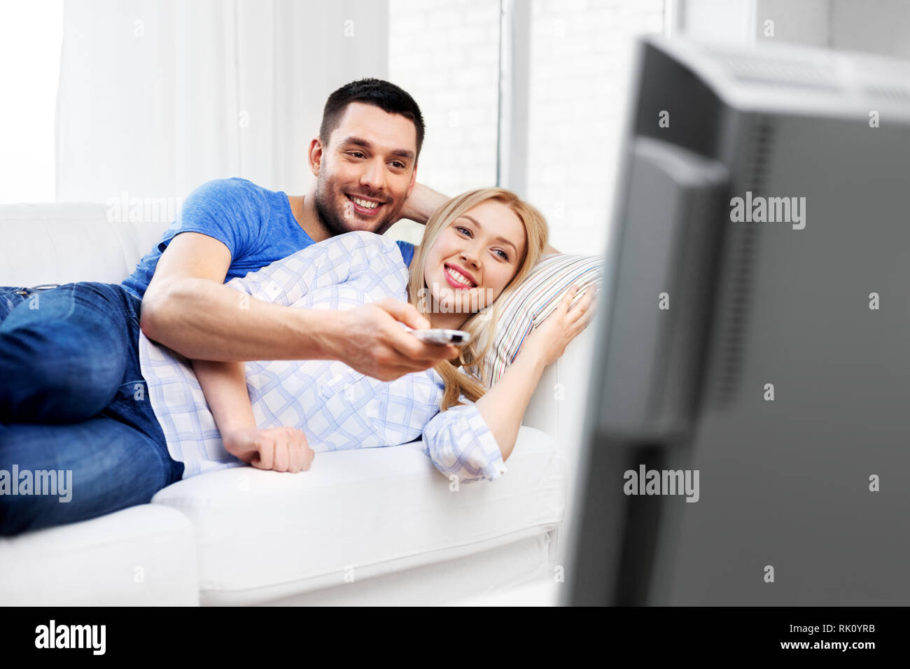 happy smiling couple watching tv at home Stock Photo - Alamy