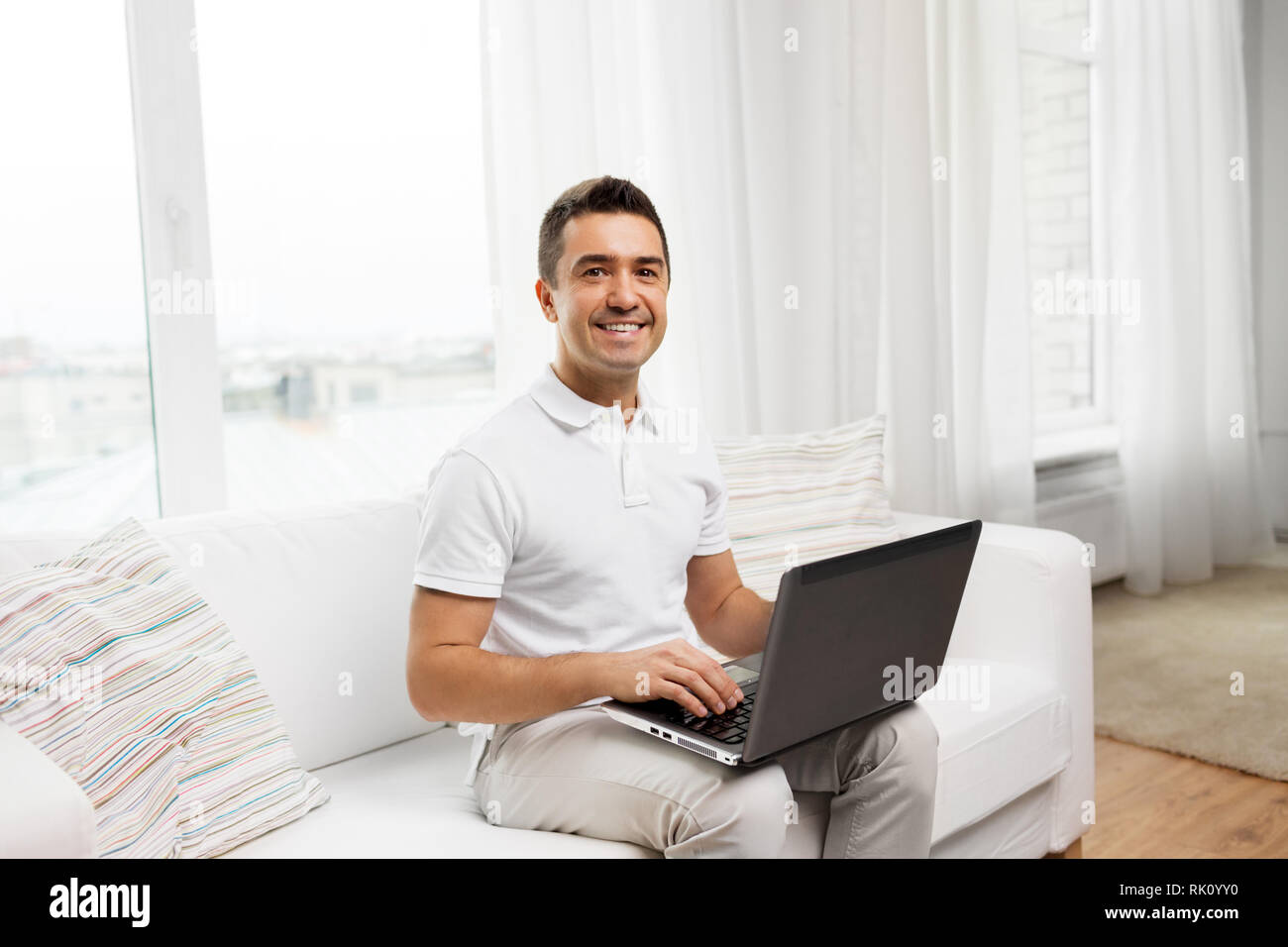 happy man with laptop computer at home Stock Photo - Alamy