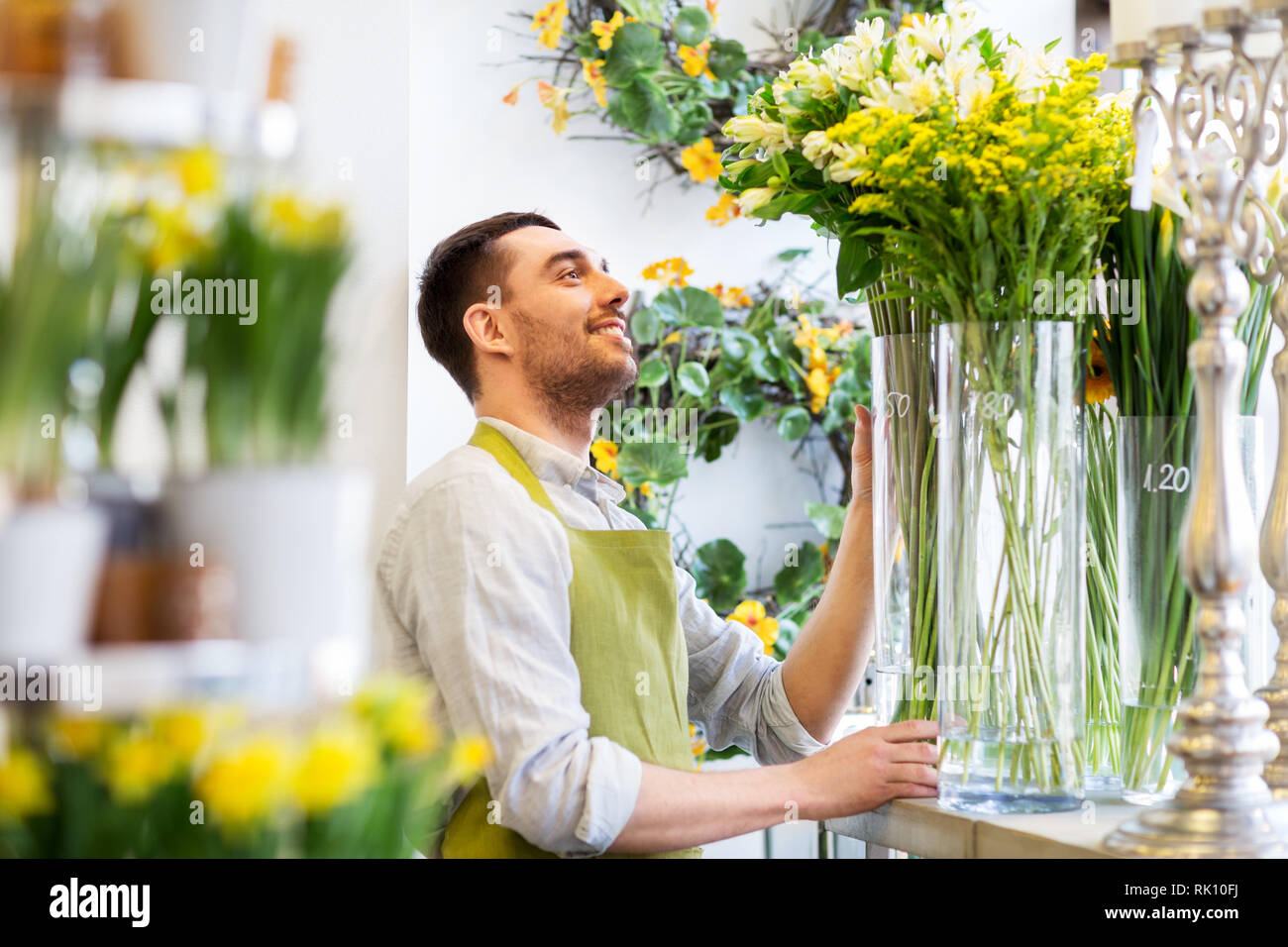 happy florist man setting flowers at flower shop Stock Photo - Alamy