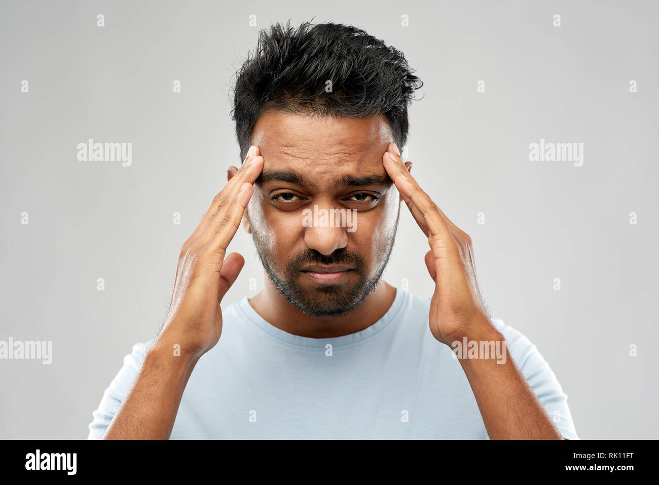 unhappy indian man suffering from headache Stock Photo - Alamy