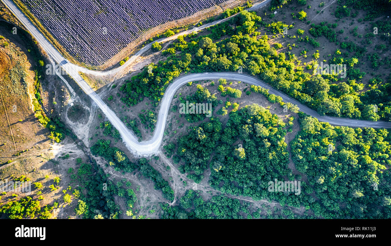 Aerial view over mountain road going through forest landscape - Image ...