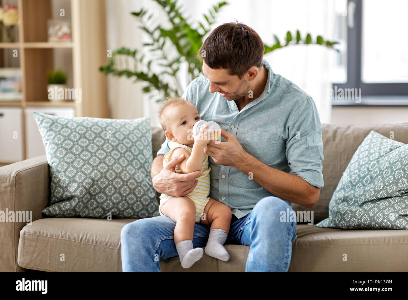 father and baby drinking from bottle at home Stock Photo - Alamy