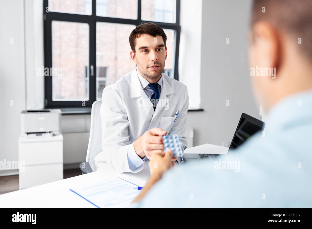 doctor giving medicine to male patient at hospital Stock Photo - Alamy