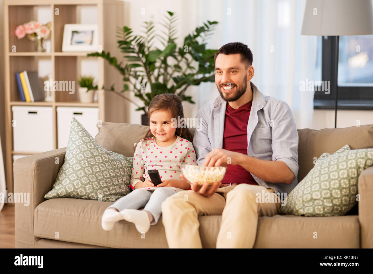 happy father and daughter watching tv at home Stock Photo - Alamy