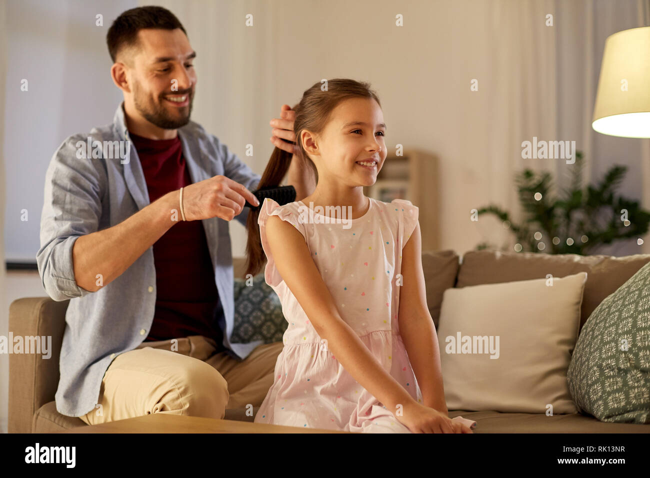 father brushing daughter hair at home Stock Photo - Alamy