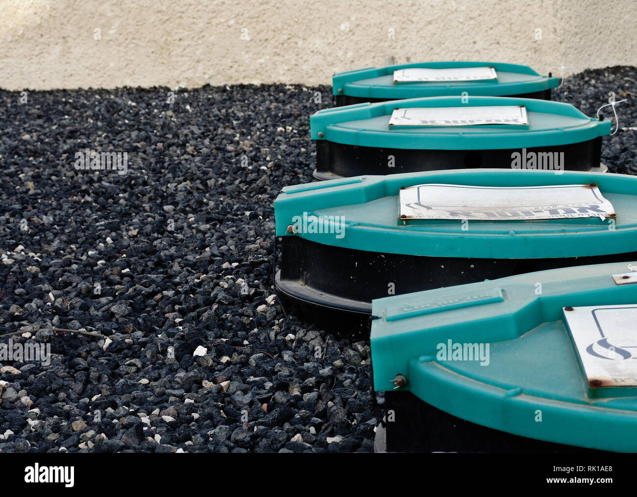 Four big cylindrical containers, with green lids covered, placed mostly ...