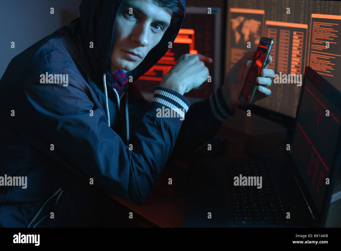 Male in the hood looking in the camera. Hacker attacks and online fraud ...