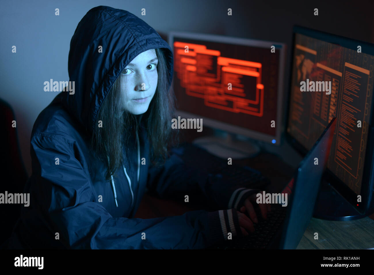 Girl in the hood looking in the camera. Hacker attacks and online fraud ...