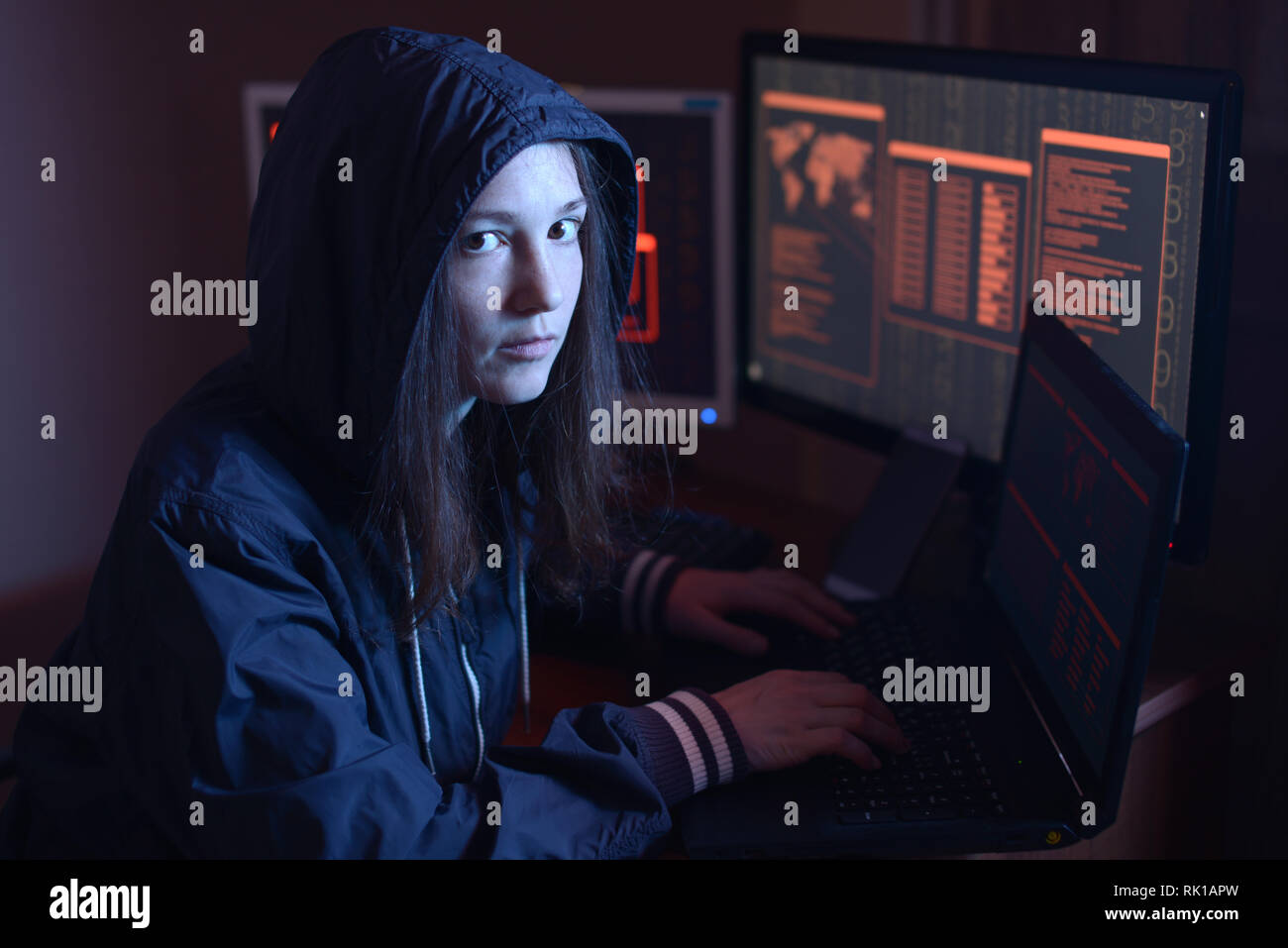 Girl in the hood looking in the camera. Hacker attacks and online fraud ...