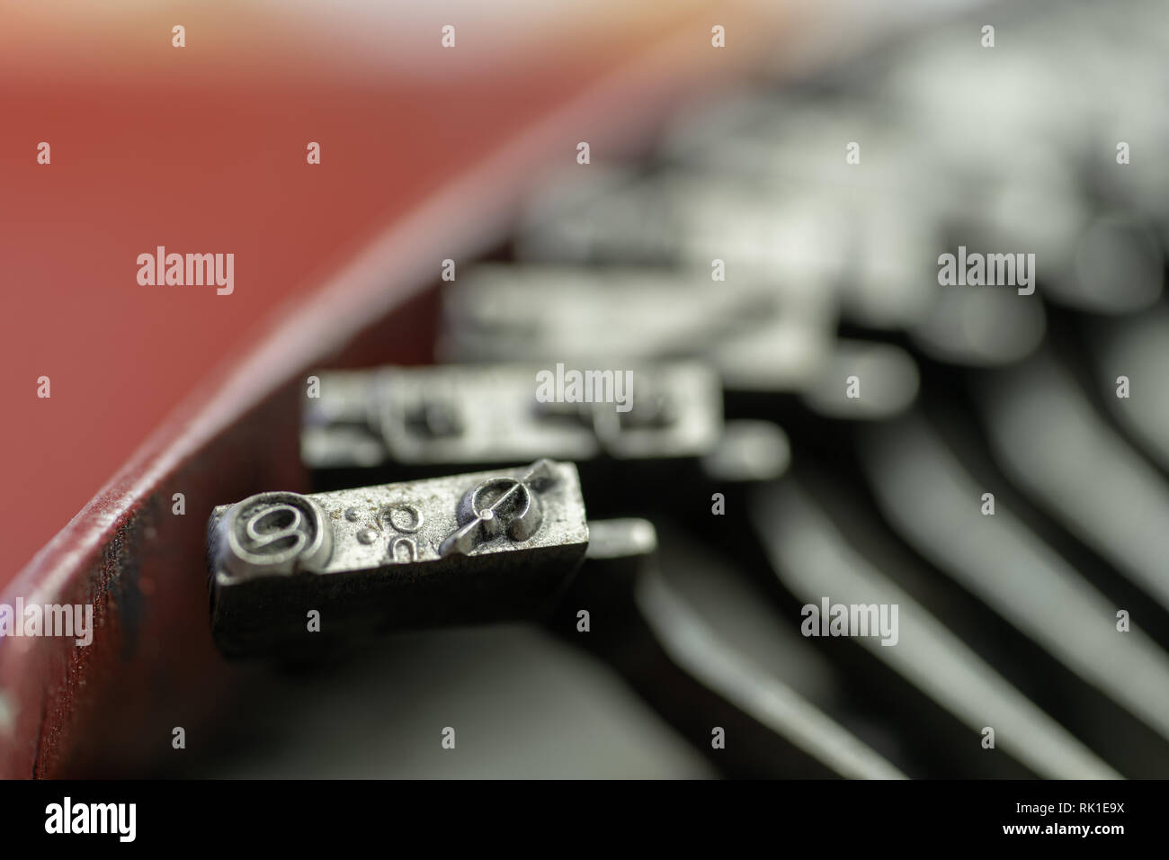 A closeup of a letter block and striker arm of an antique typewriter ...