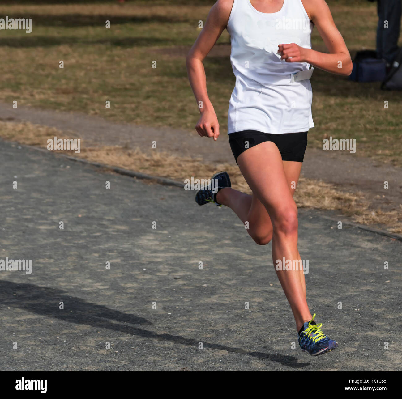 A high school female cross country runner runner racing on a gravel ...