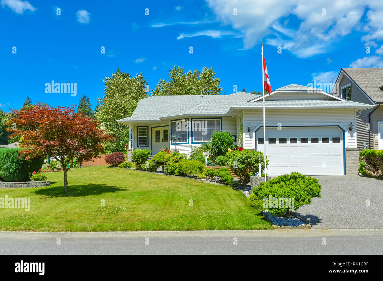Suburban family house with nice lawn, wide garage door, and concrete ...