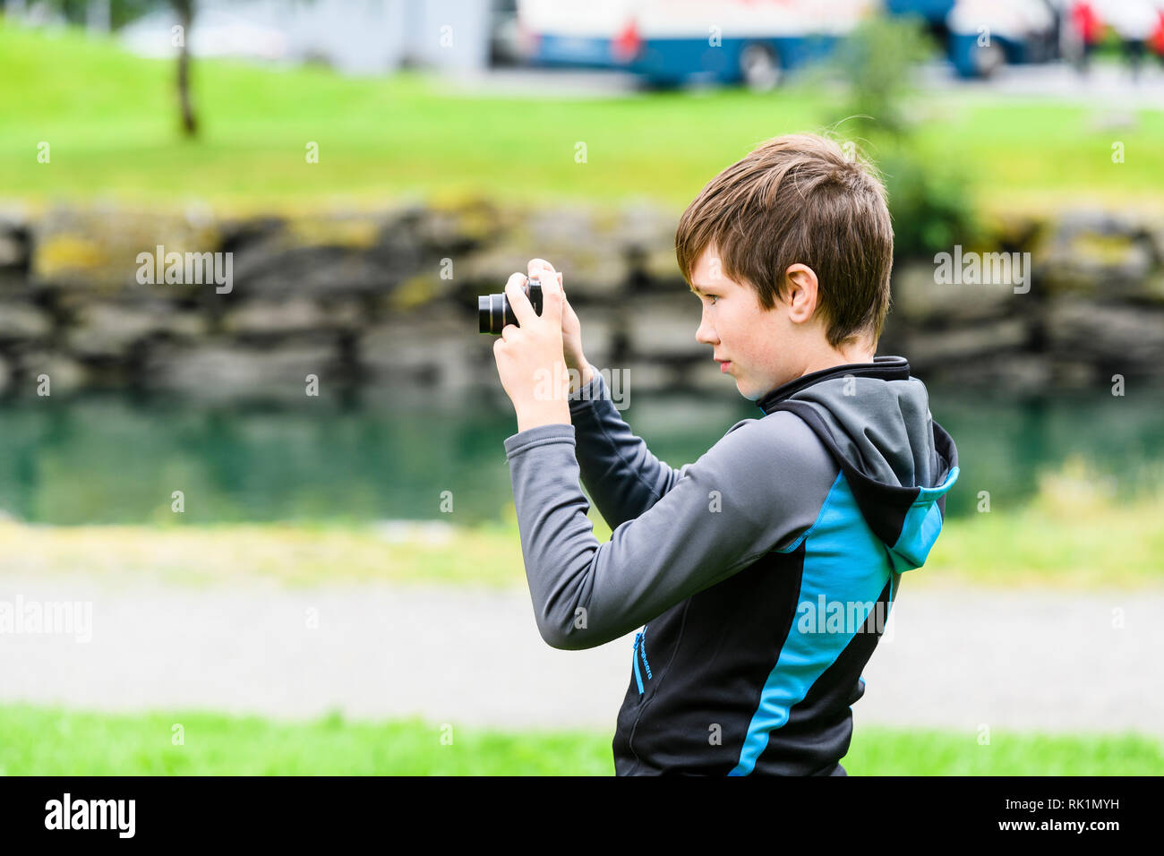 Young boy looking through lens of digital camera, creativity and focus ...