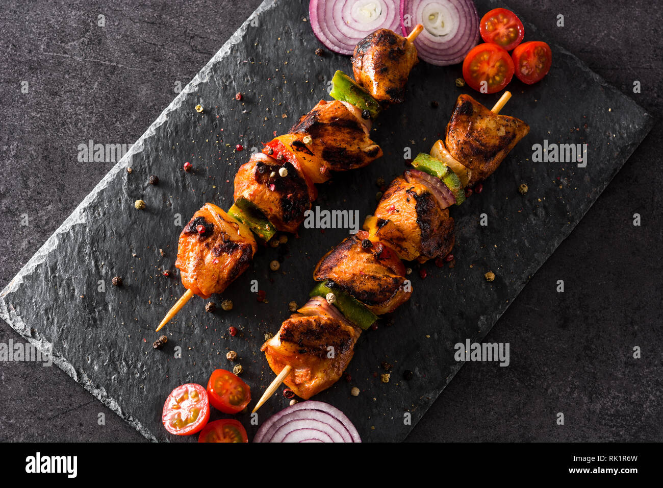 Chicken shish kebab with vegetables on black stone Stock Photo - Alamy