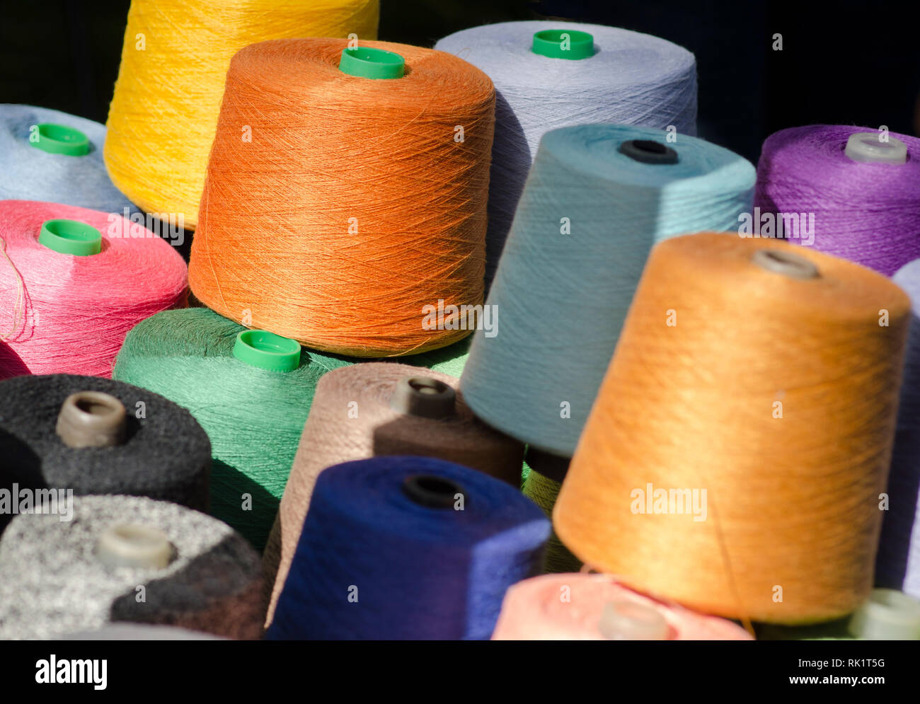 Colorful thread spools, one above the other. Coils with colurful ...
