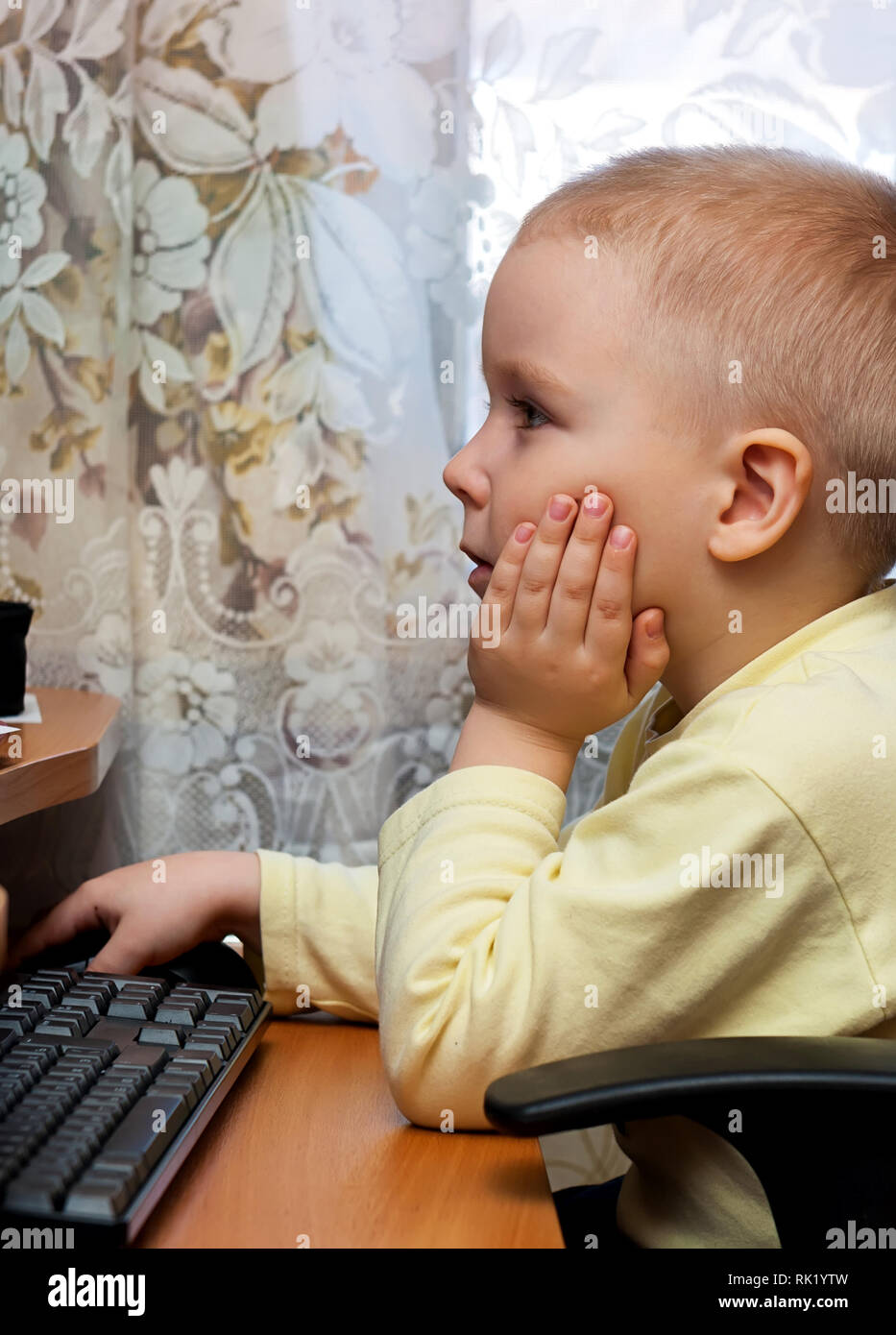 young handsome boy is sitting on chair and working seriously with ...