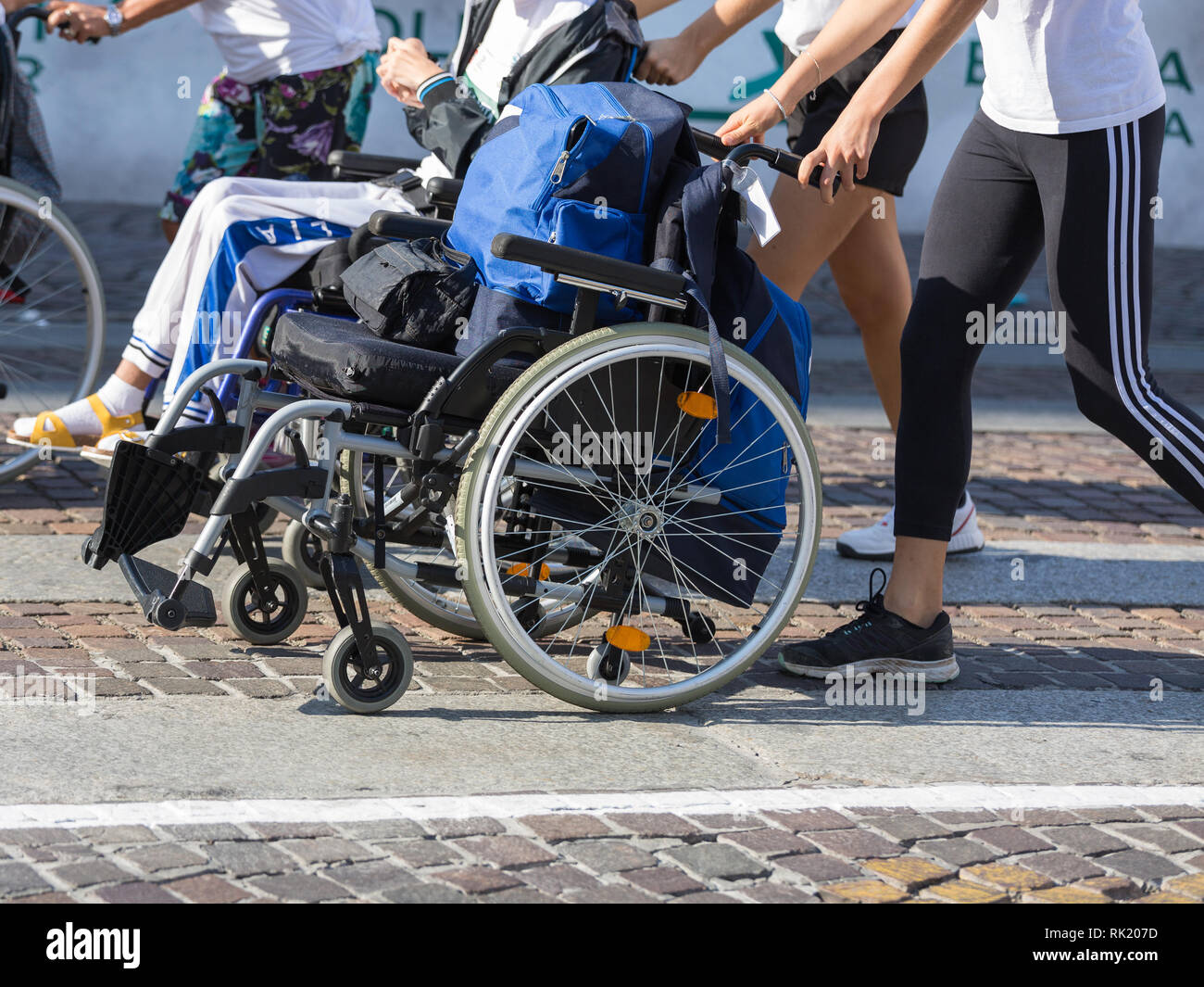 Disabled Athlete in a Sport Wheelchair during Marathon Helped by Female ...