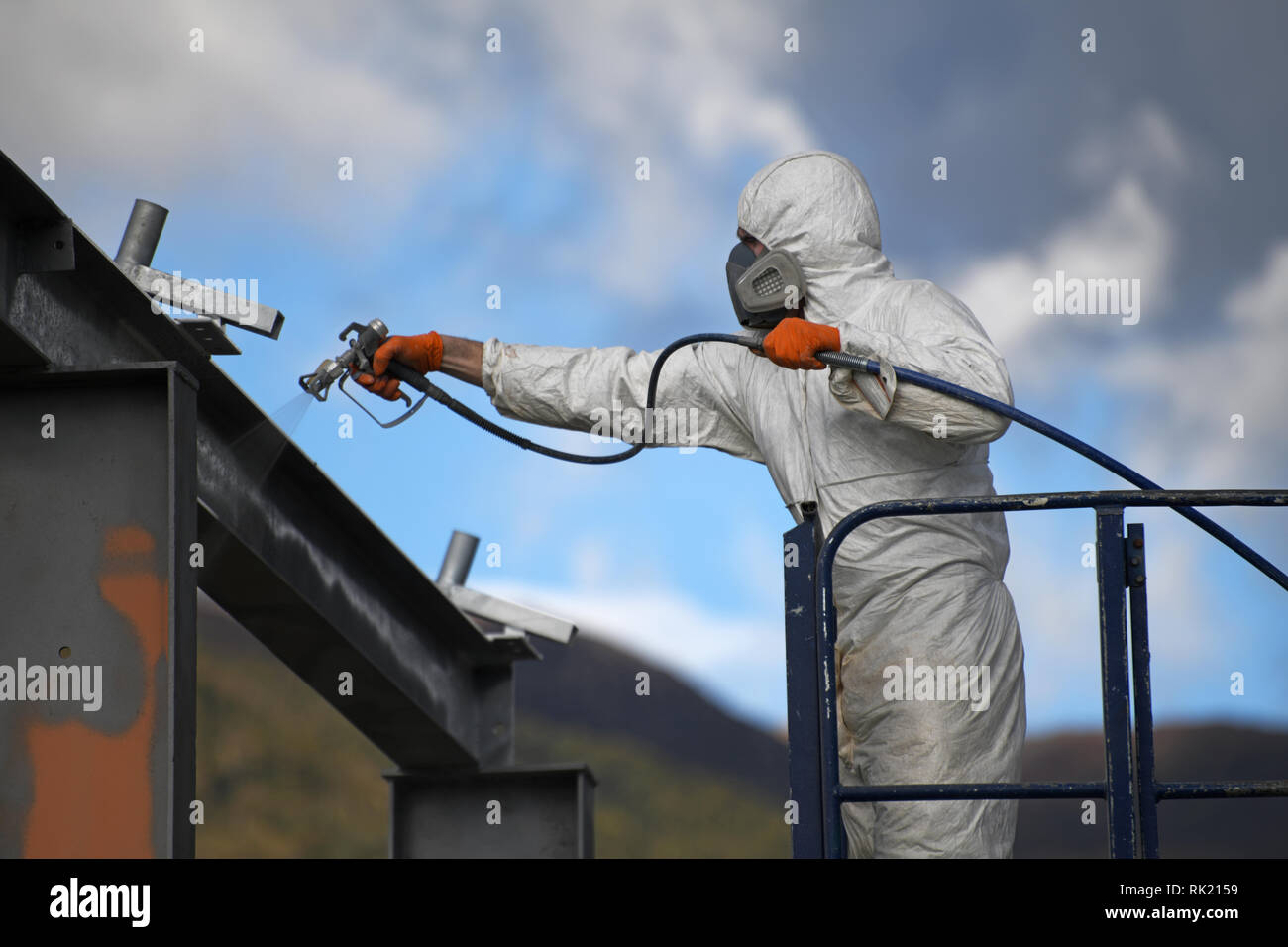 Tradesman spray paints the steel beams on a construction site Stock ...