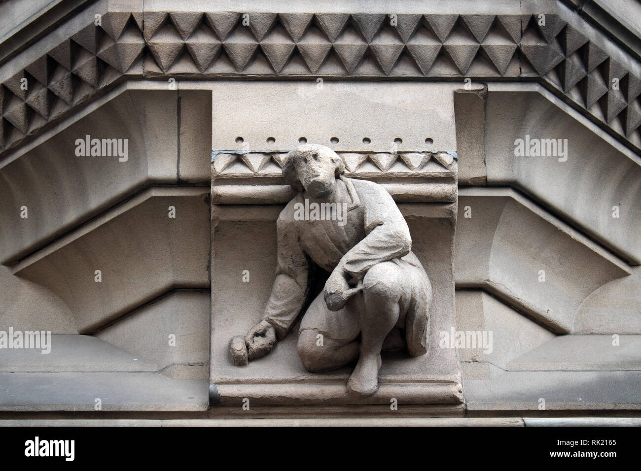 A stone carving of a sitting figure, an architectural detail of a ...