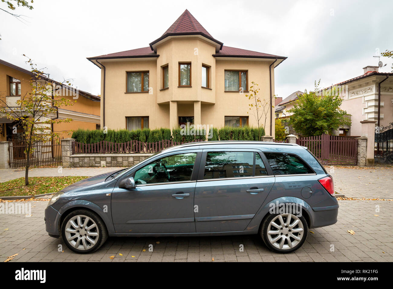 New expensive gray car parked in paved parking lot in front of big two ...