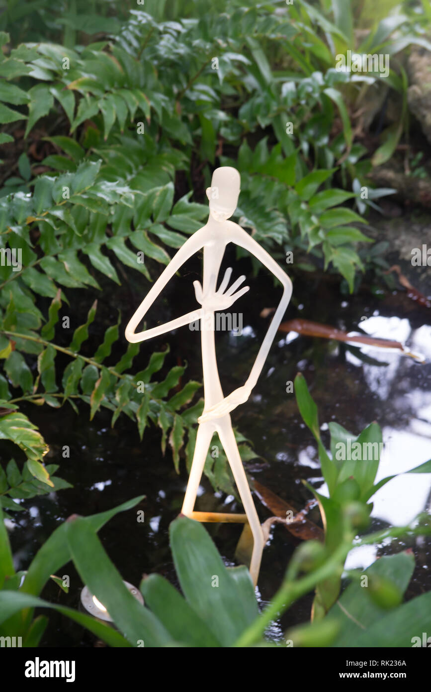 Glass artistic stick figure in garden setting Stock Photo - Alamy