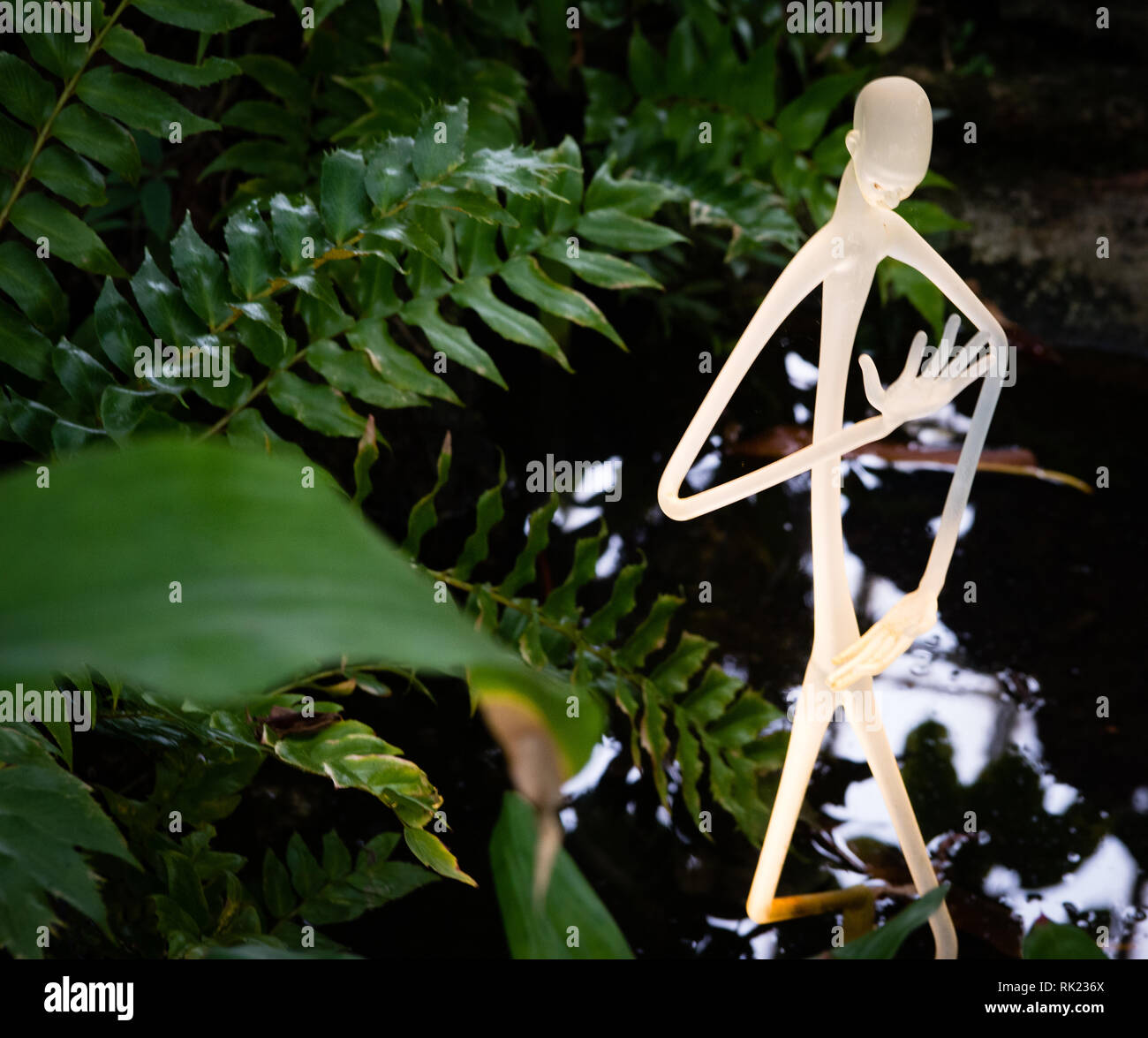 Glass artistic stick figure in garden setting Stock Photo - Alamy