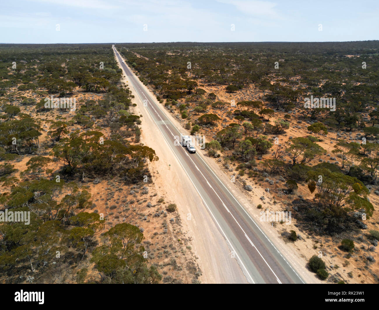 Aerial of car and caravan travelling through mallee country on the Eyre ...