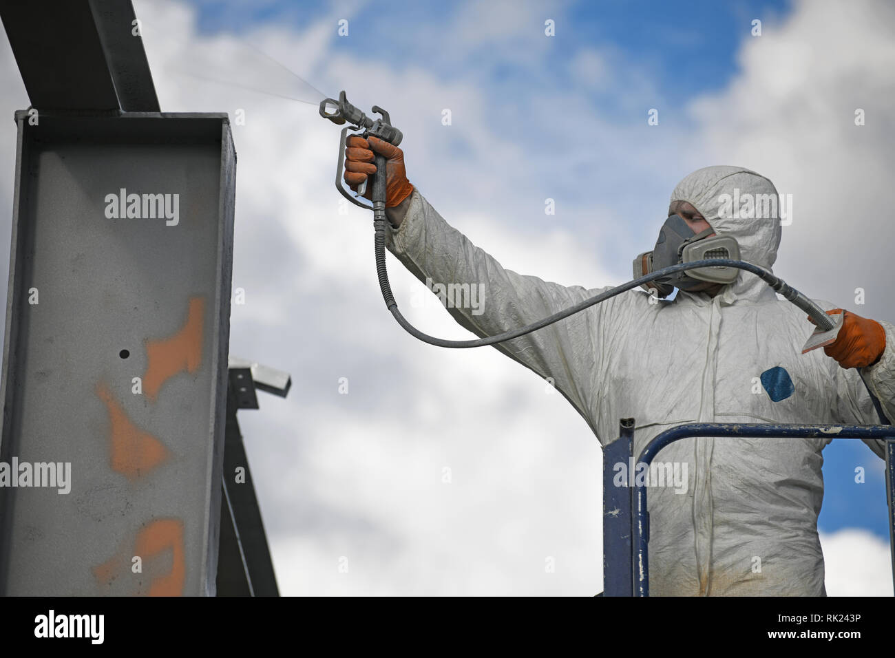 Tradesman spray paints the steel beams on a construction site Stock ...