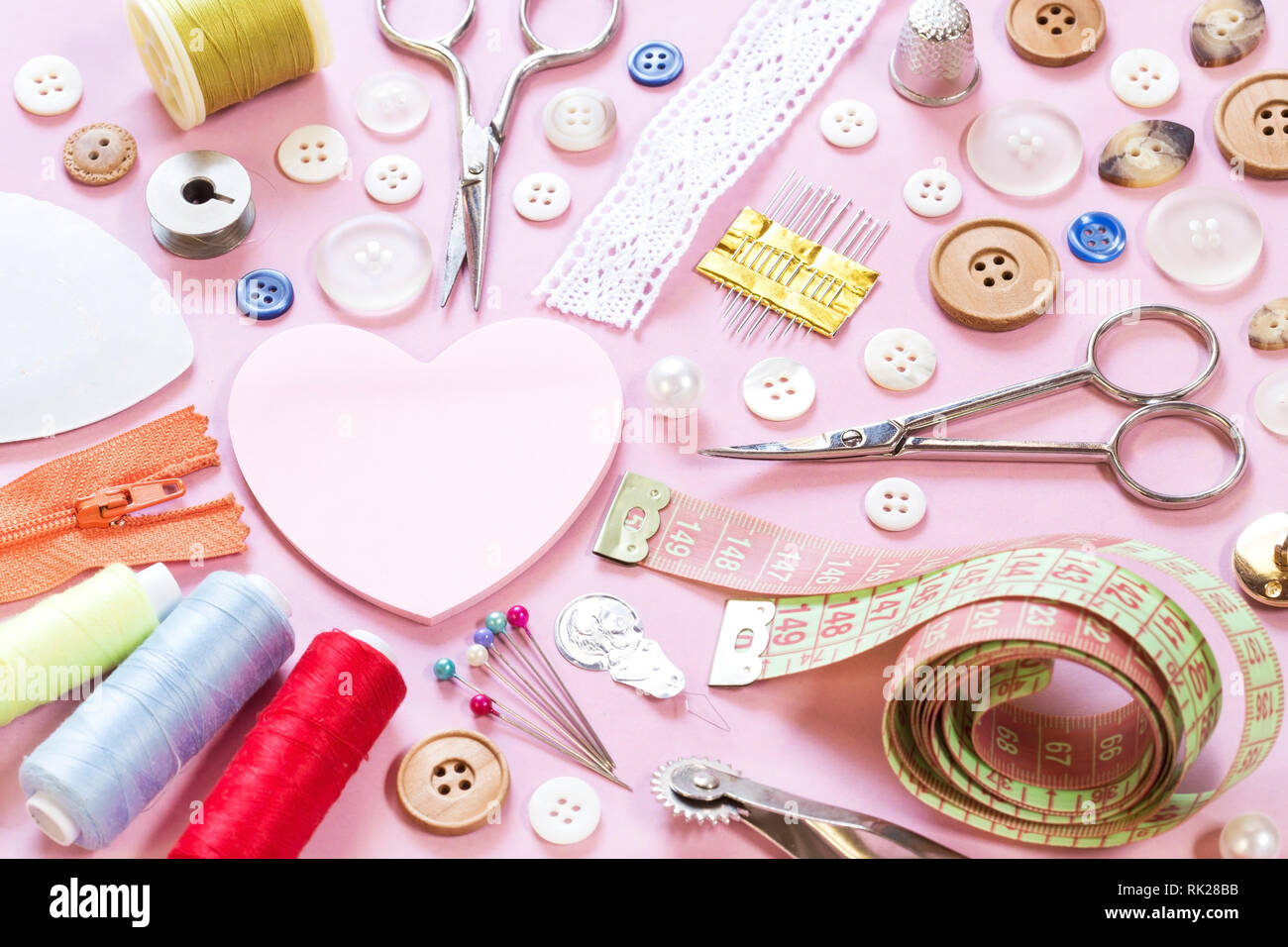Sewing items on pink background Stock Photo - Alamy