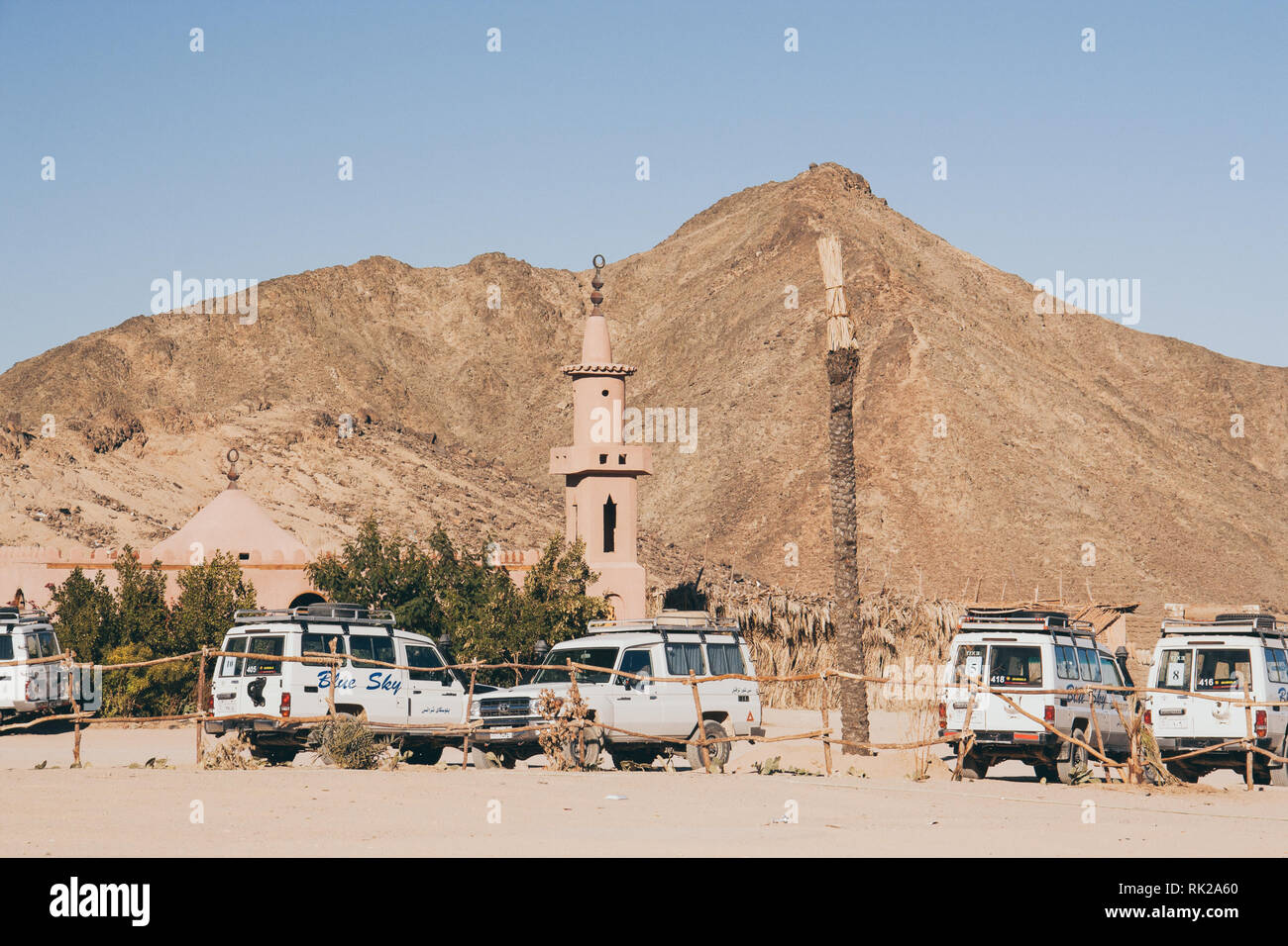 Four tourist jeeps in egyptian desert with mountains on background ...