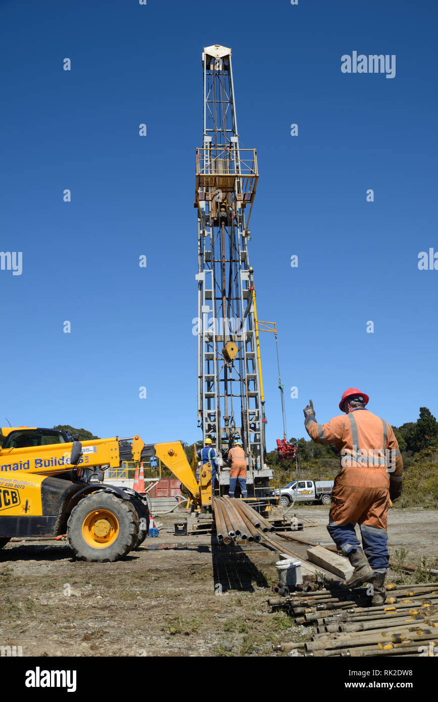 DOBSON, NEW ZEALAND, OCTOBER 13, 2018: Engineers feed the drill string ...