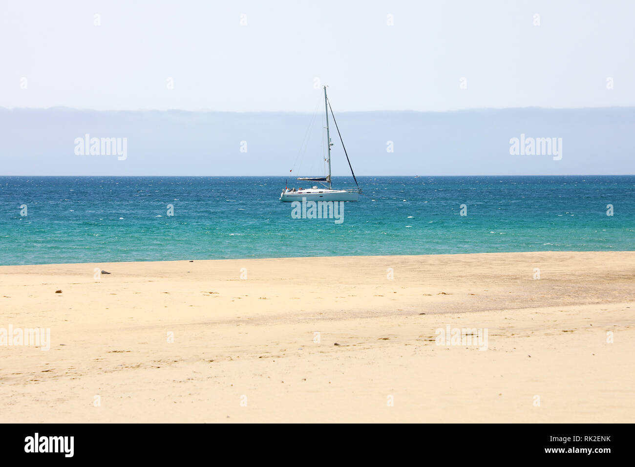 Marine landscape with sailing boat, white sand beach and blue sea ...