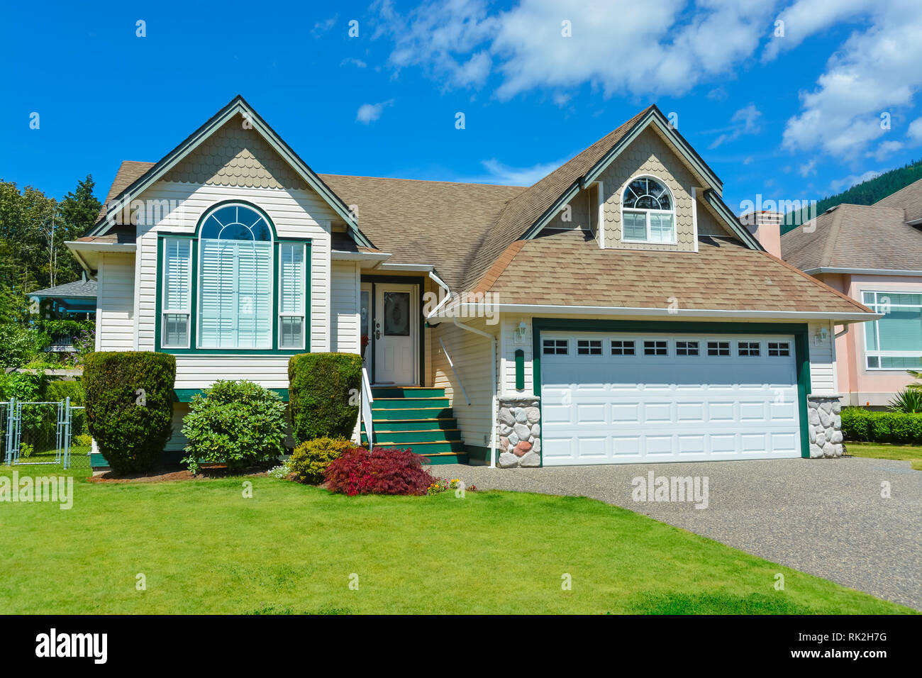 Suburban house with concrete driveway and blue sky background. House ...