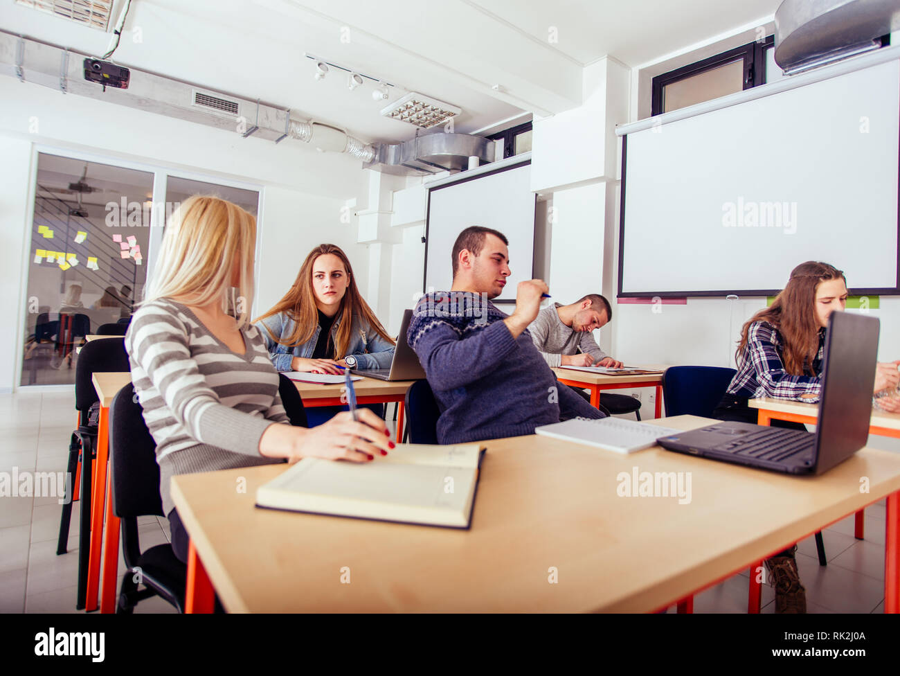 Group of young people are listening carefully to their classmate Stock ...