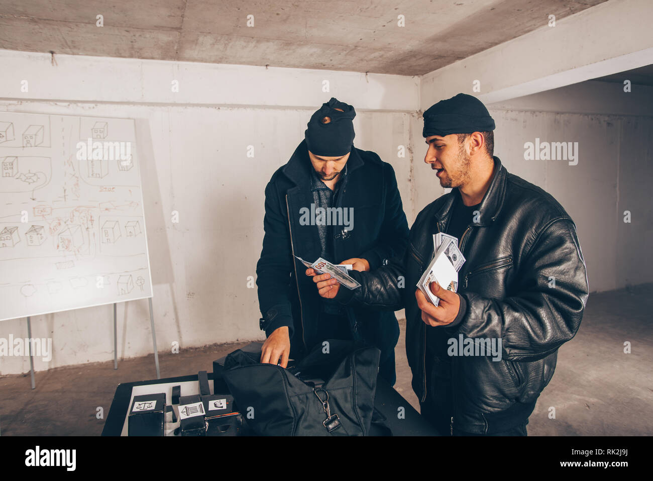 Gangsters are counting money in a dark room with a gun near them Stock ...