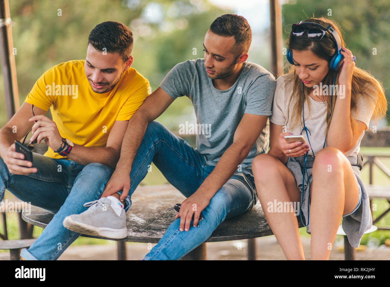 Three careless people are smiling, having fun and listening music in ...
