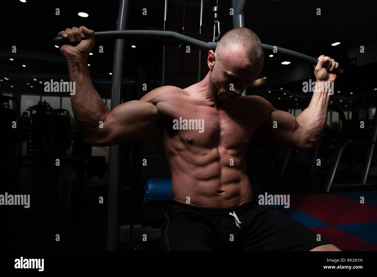 Handsome Bodybuilder Doing Heavy Weight Exercise For Back On Machine ...