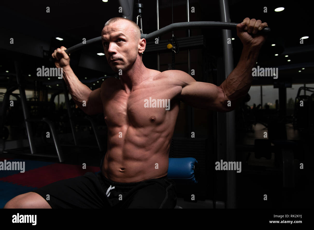 Handsome Athlete Doing Heavy Weight Exercise For Back On Machine Stock ...