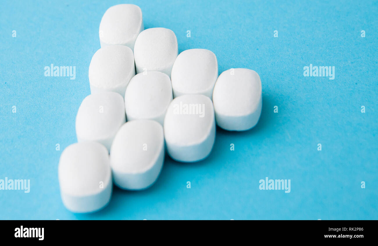 Assorted pharmaceutical medicine pills, tablets over blue background ...